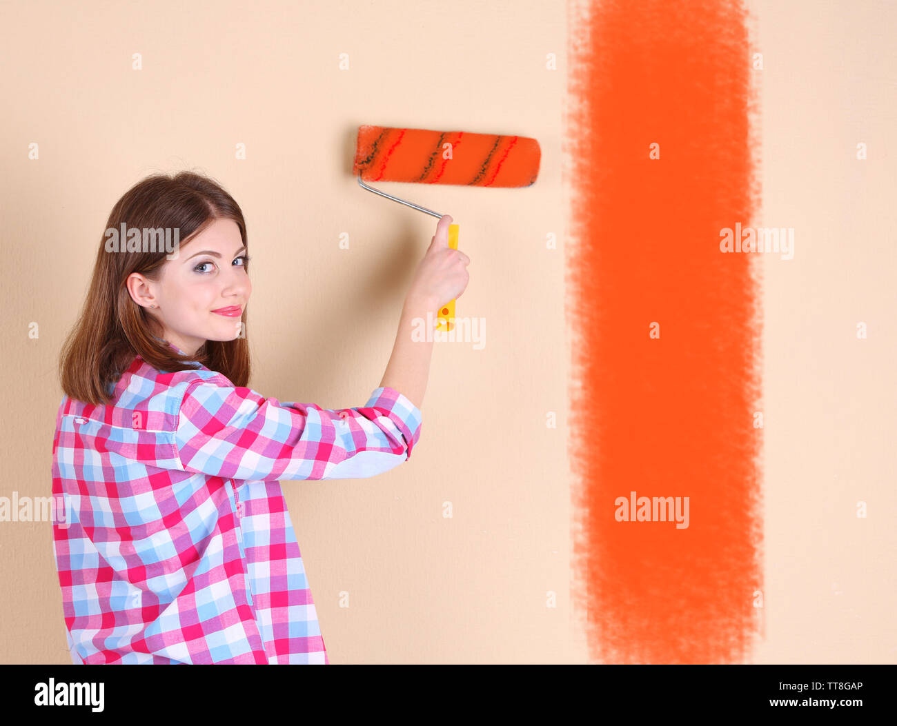 Beautiful woman paints wall in room Stock Photo - Alamy
