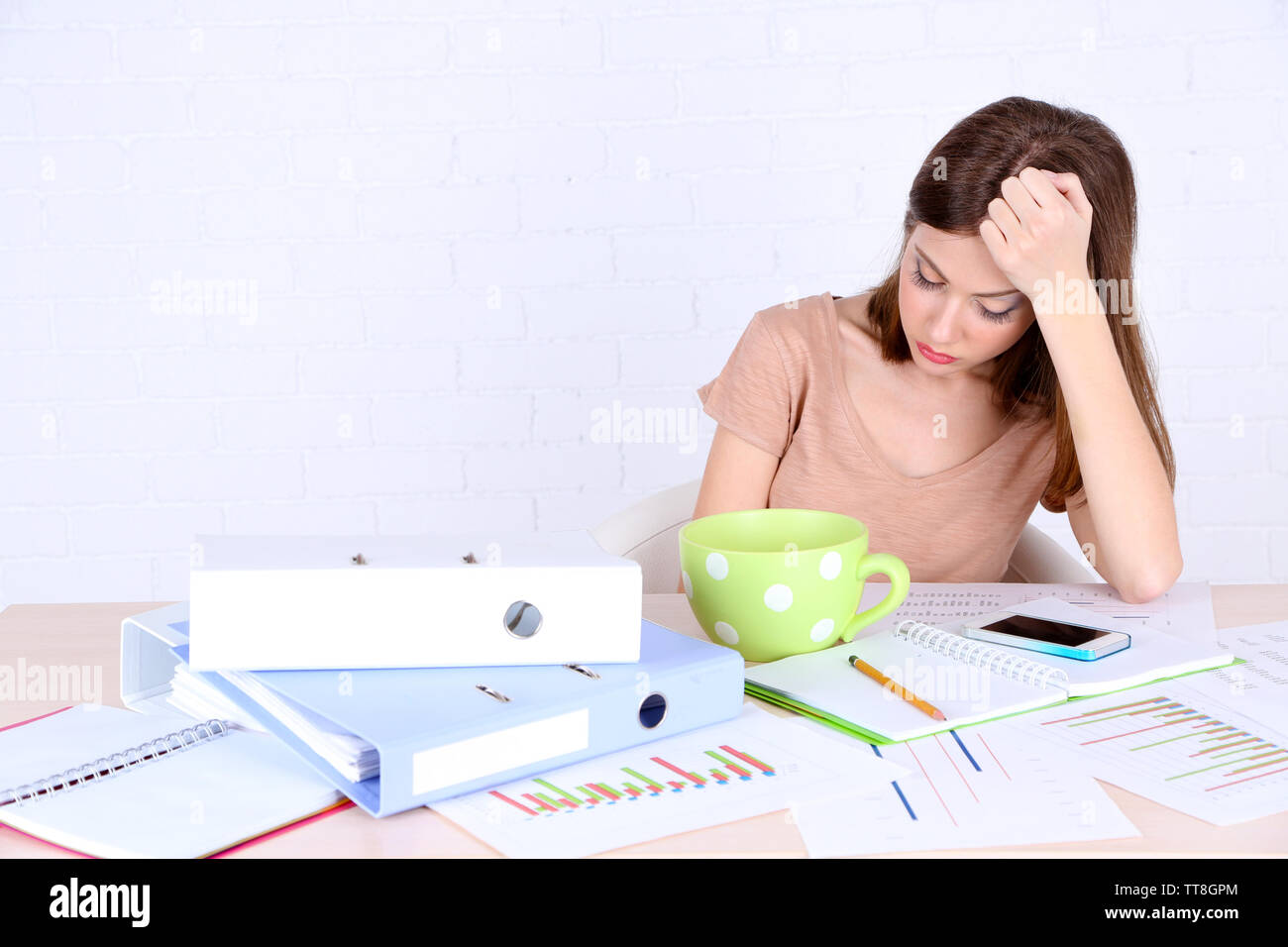 Beautiful girl slipping at table with large cup Stock Photo - Alamy