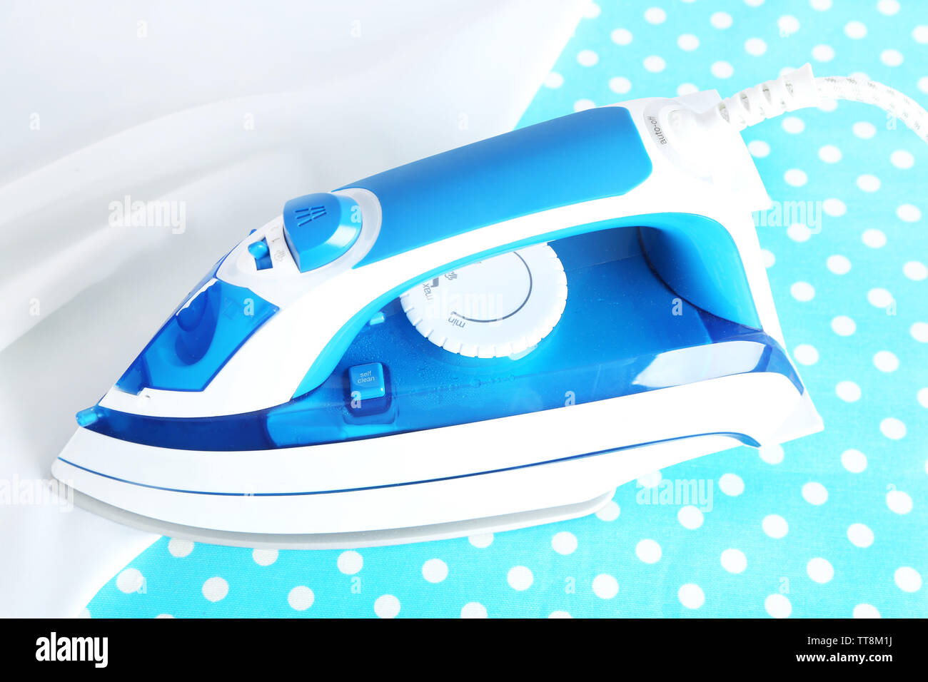 Iron on ironing board close-up Stock Photo - Alamy