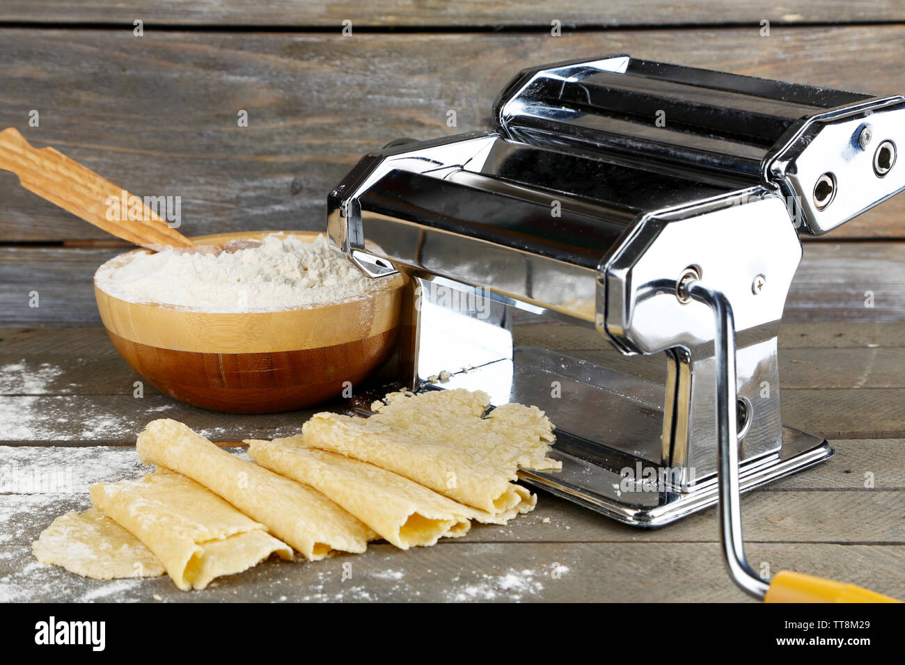 Making vermicelli with pasta machine on wooden background Stock Photo ...