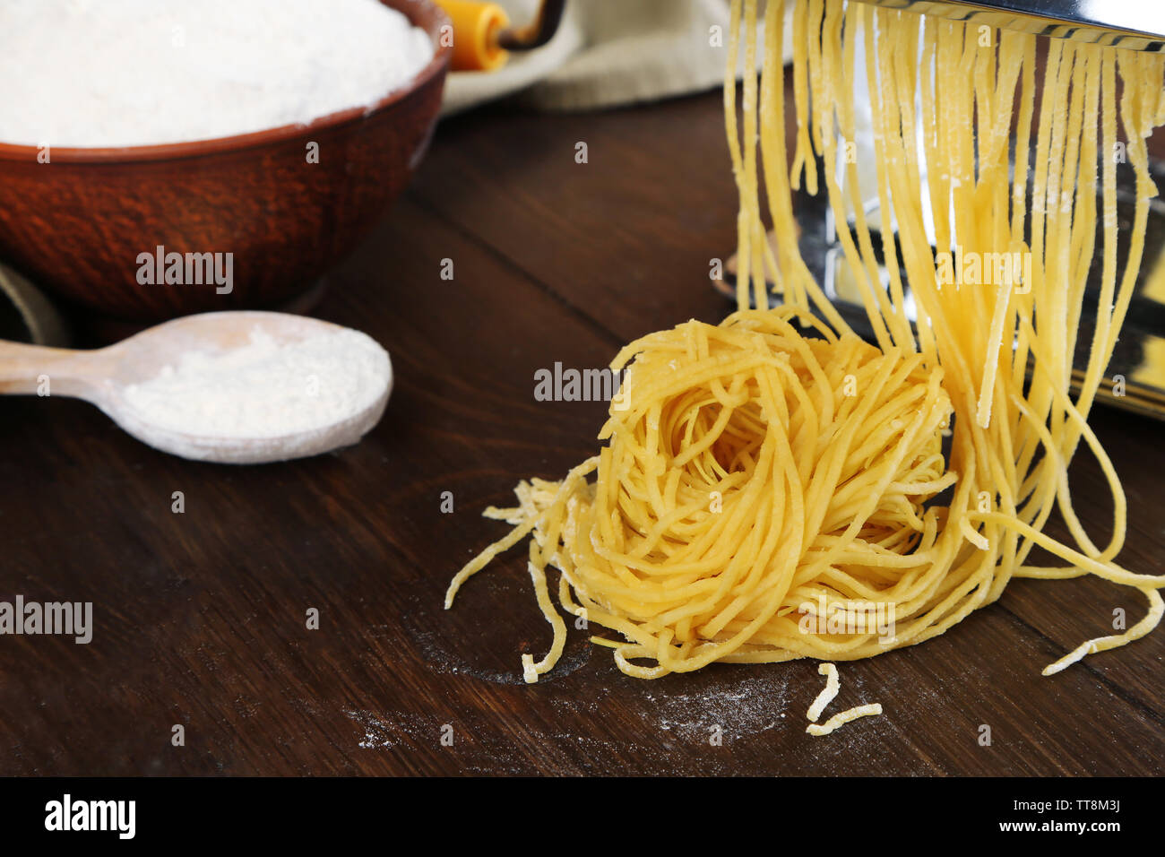 Making vermicelli with pasta machine on wooden background Stock Photo ...