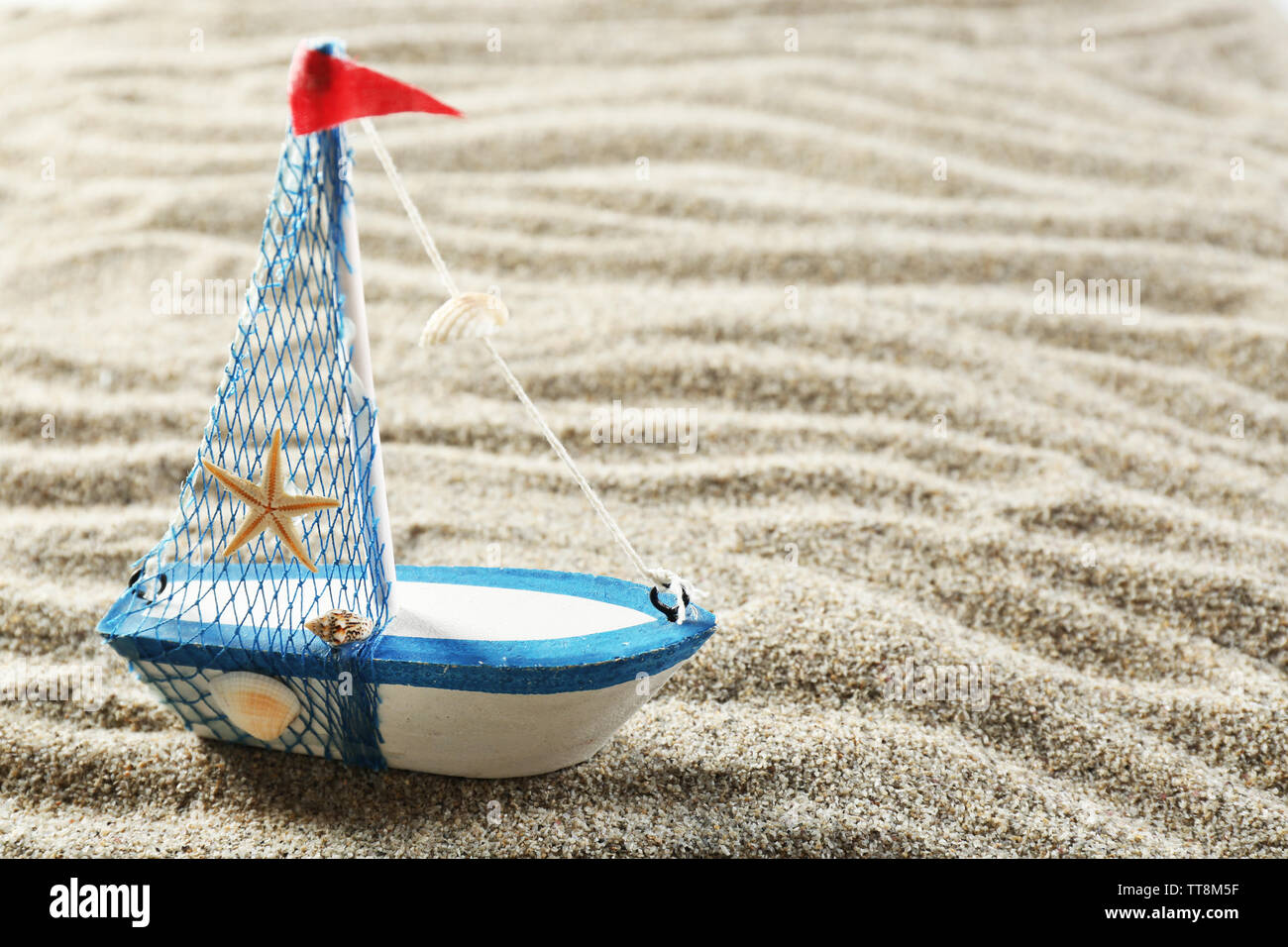 Toy model of ship on sea sand background Stock Photo - Alamy