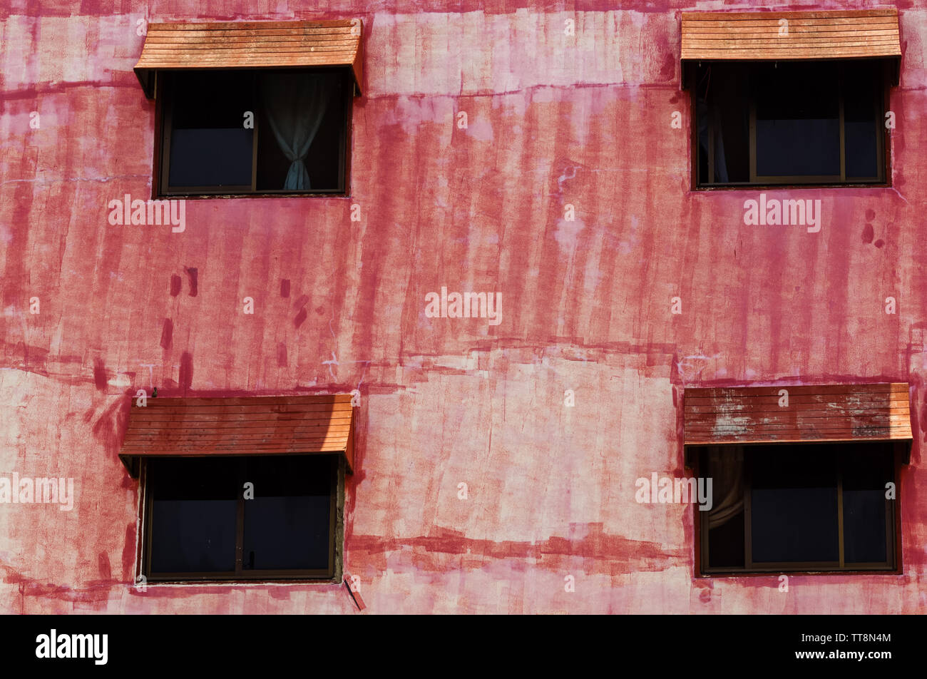 The colorful wall of an house with four windows Stock Photo - Alamy