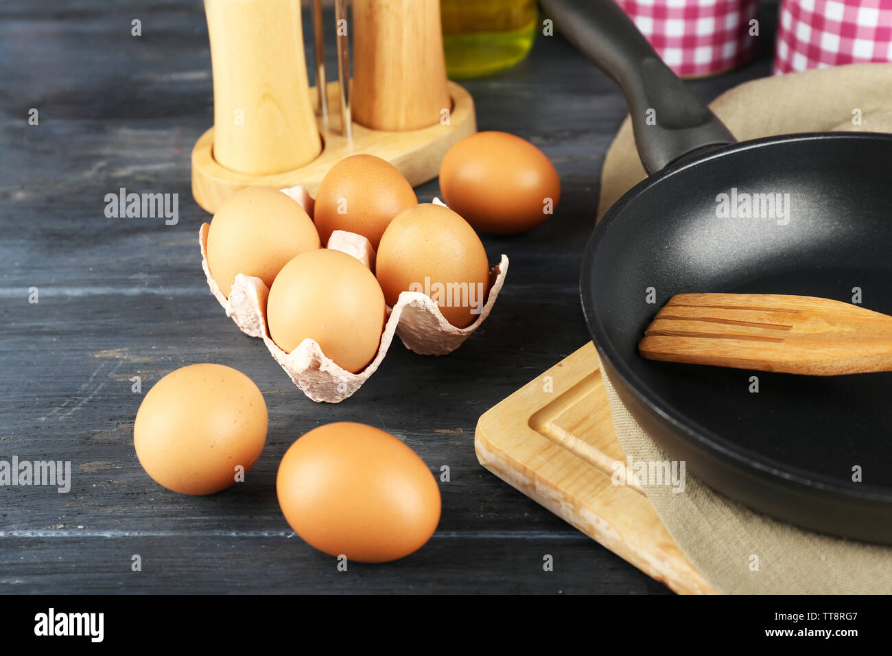 Still life with eggs and pan on wooden background Stock Photo - Alamy