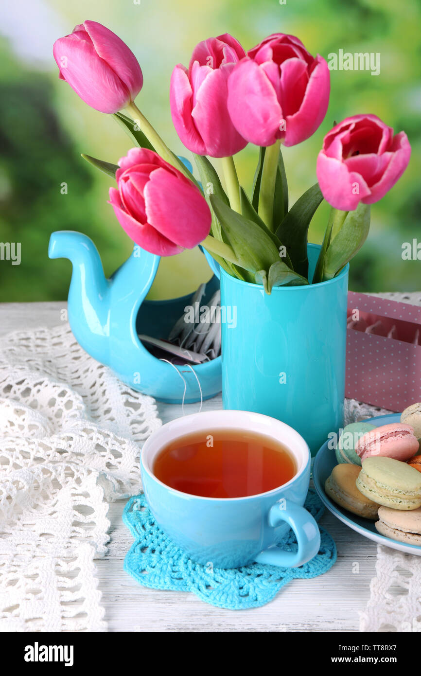 Composition of spring flowers, tea and cookies on table on natural ...
