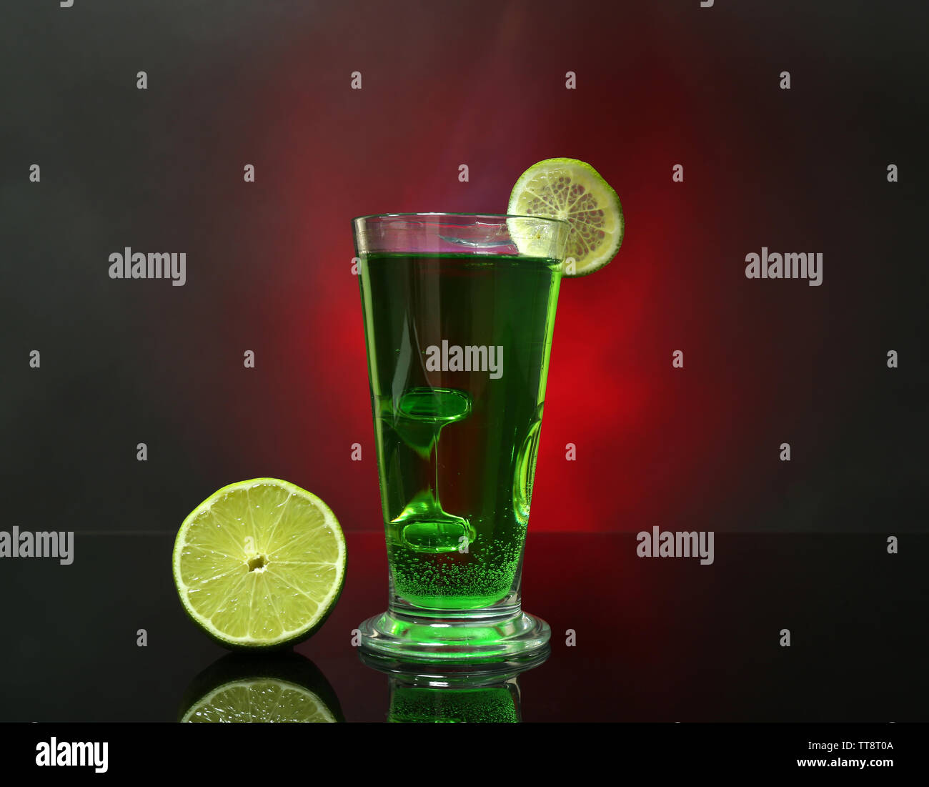 Flaming green cocktail on colorful background Stock Photo - Alamy