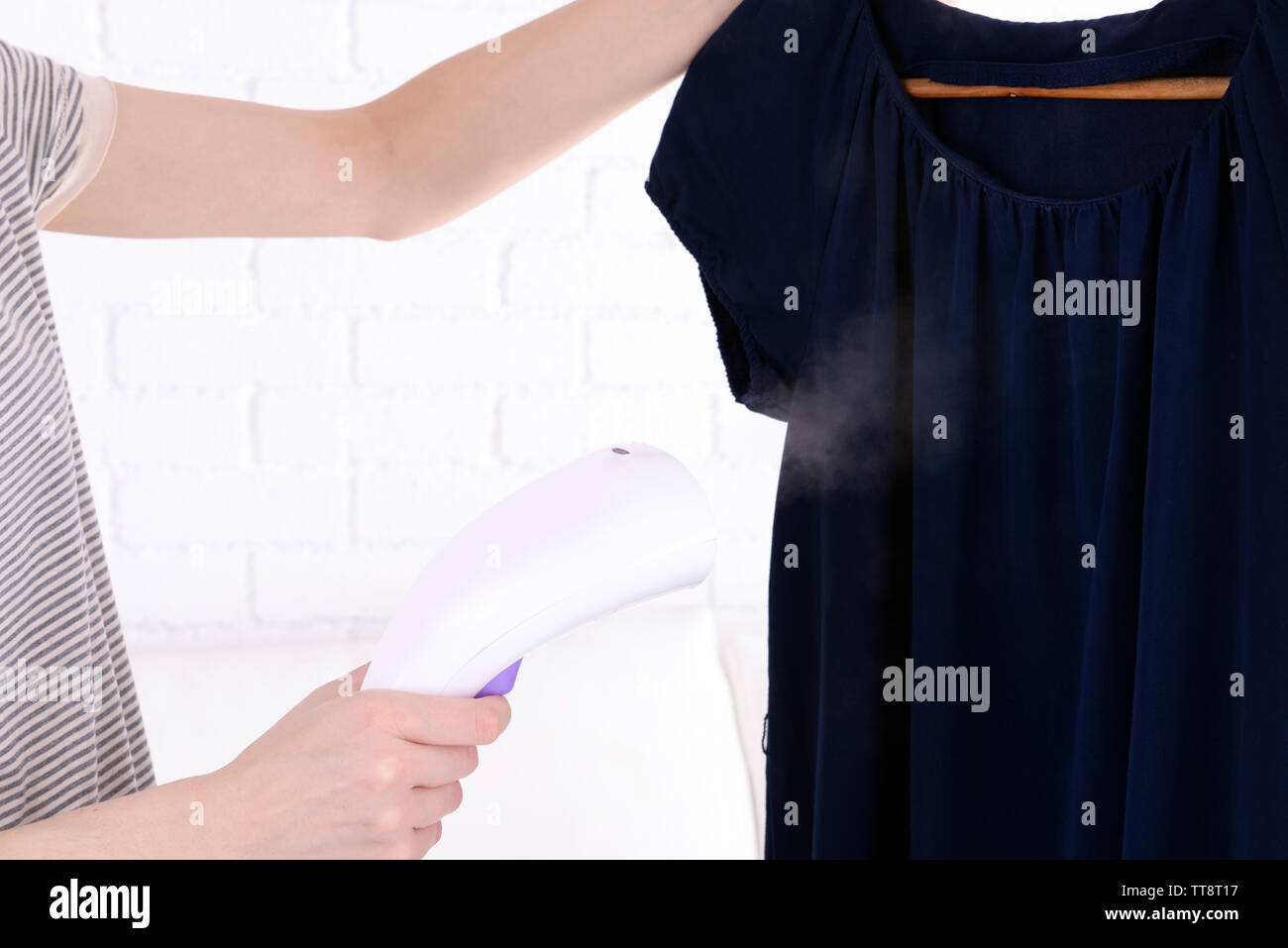 Women steaming dress in room Stock Photo - Alamy