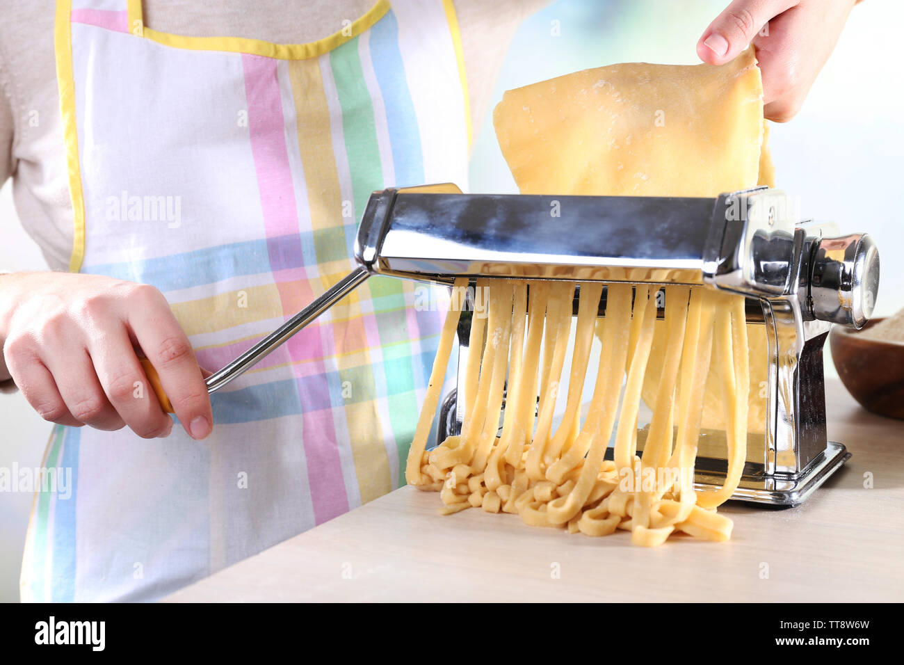 Woman making noodles with pasta machine, closeup Stock Photo - Alamy
