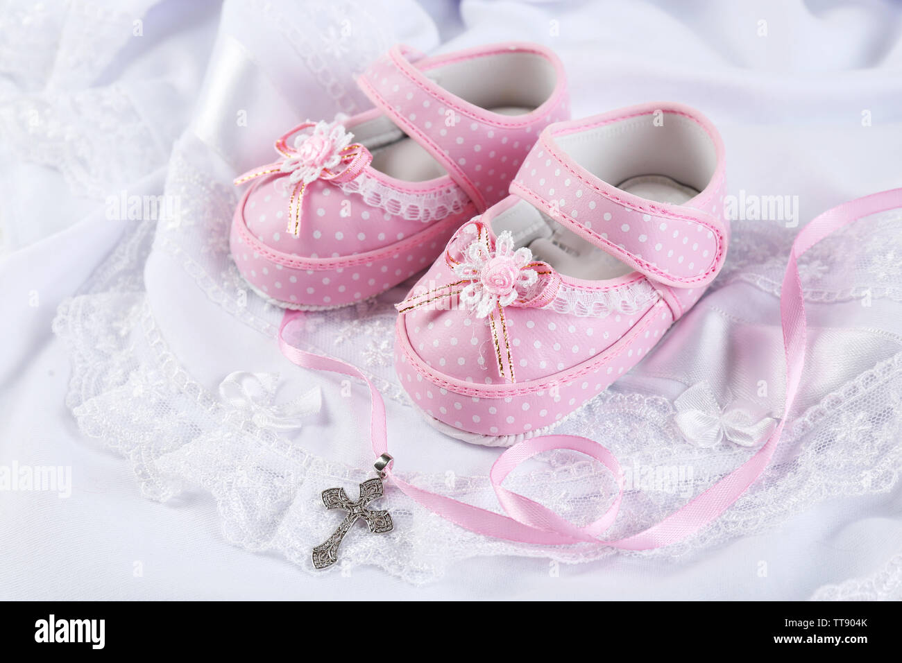Baby shoe and cross for Christening Stock Photo - Alamy