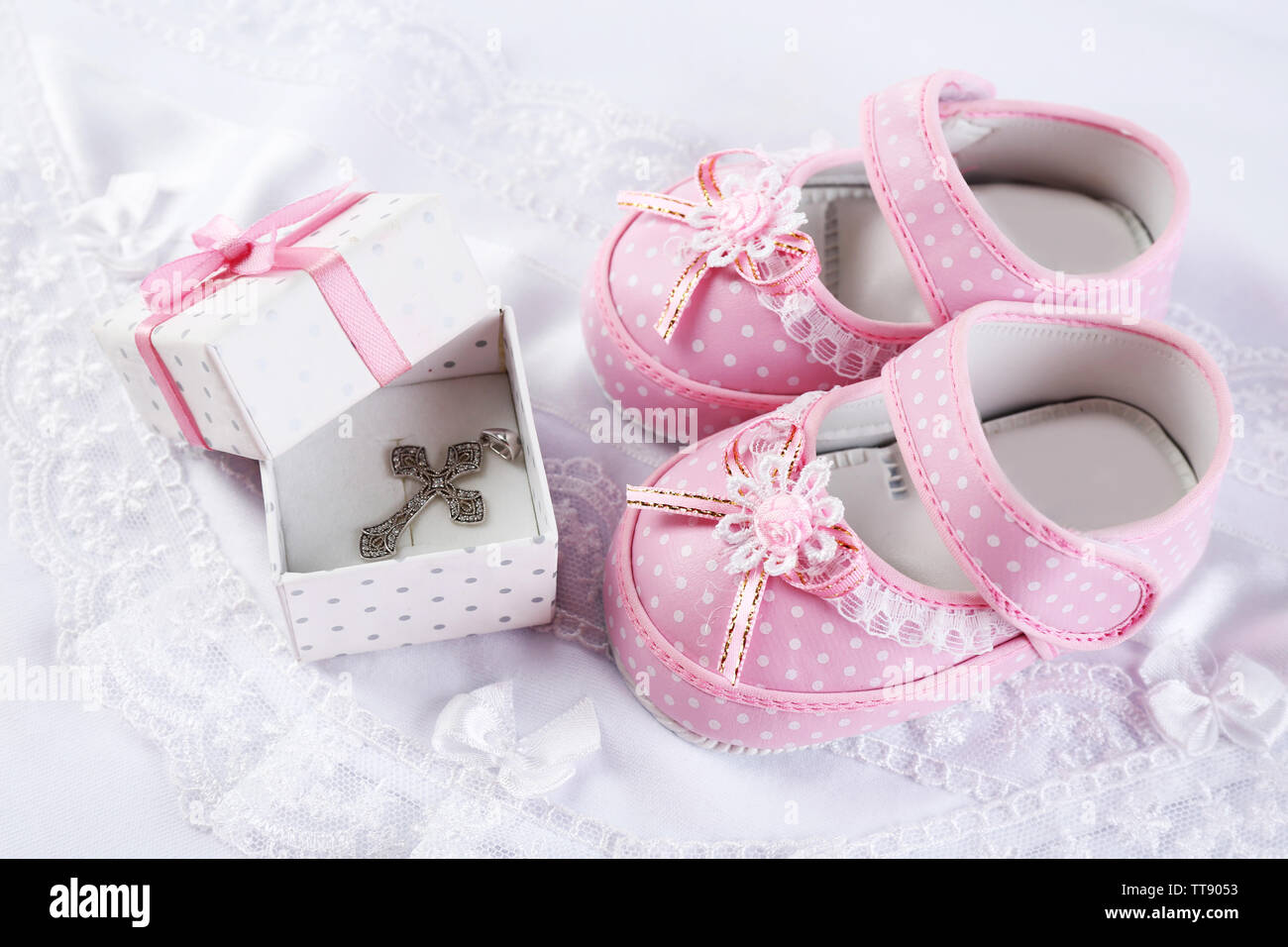 Baby shoe and cross for Christening Stock Photo - Alamy