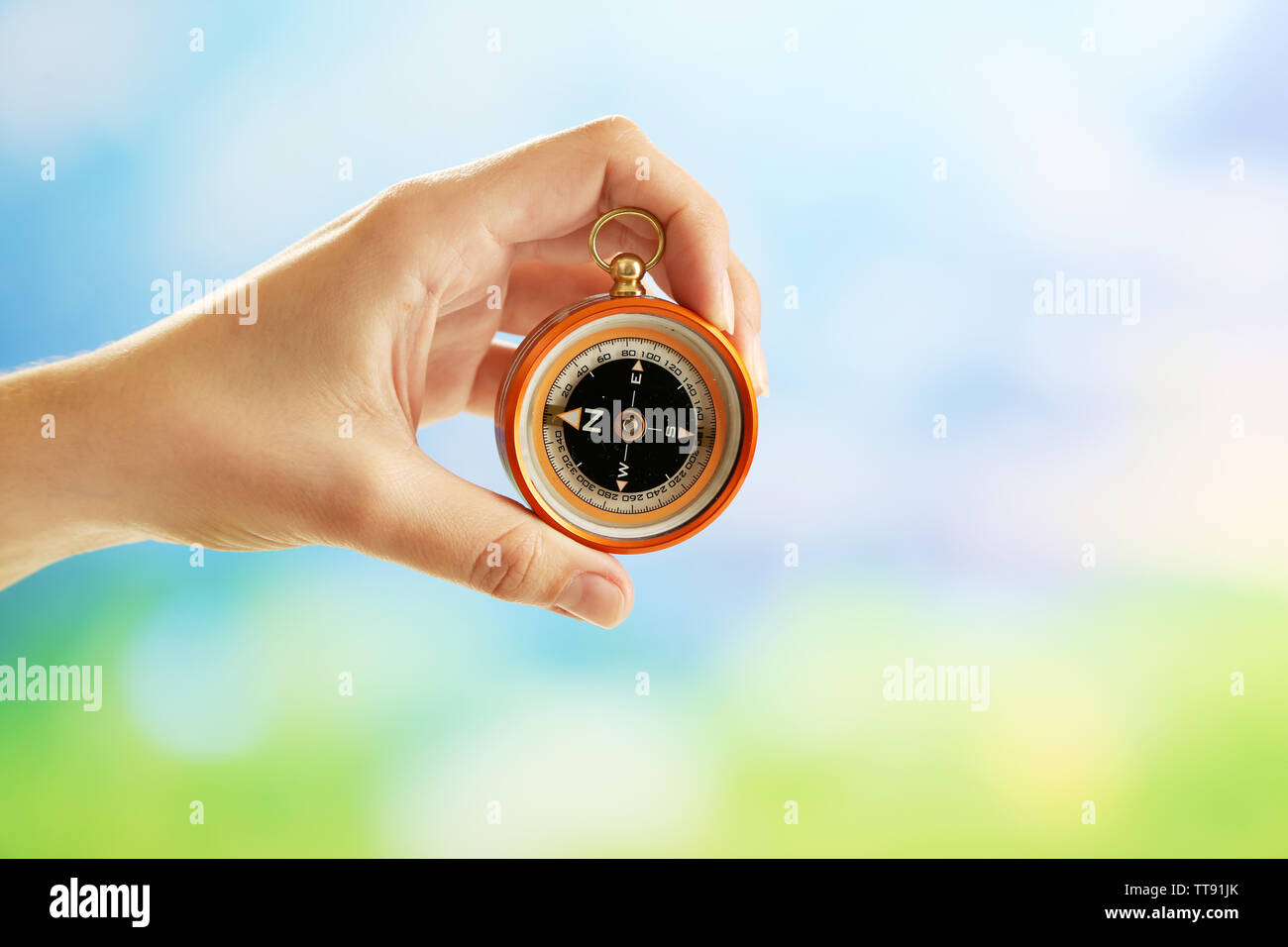 Female hand with compass on bright blurred background Stock Photo - Alamy