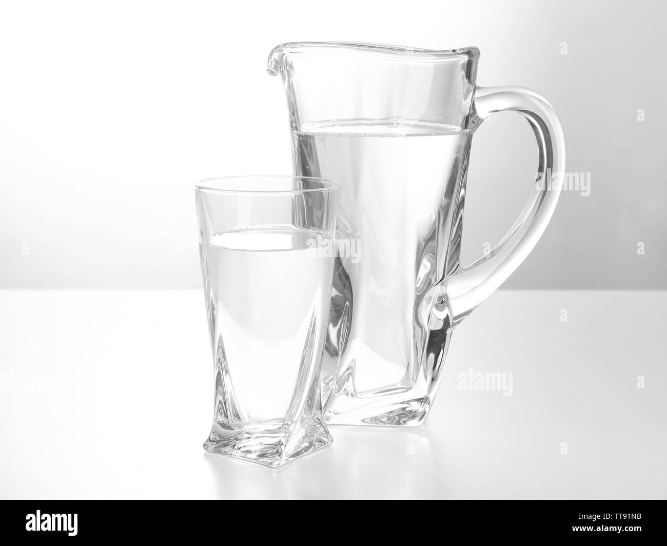 Glass pitcher and glass of water isolated on white Stock Photo - Alamy