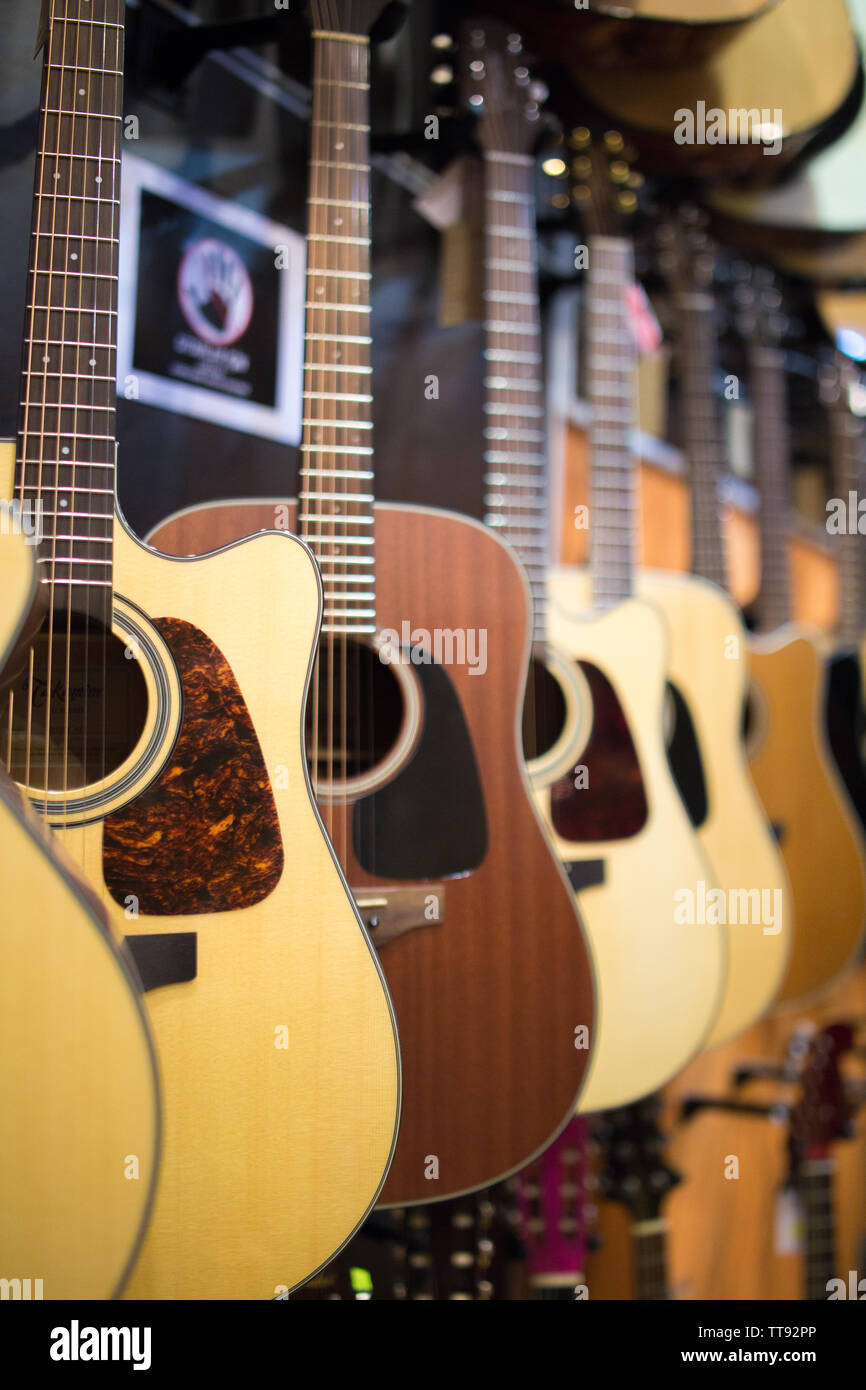 metal string acoustic guitars hanging on the walls of music store ready ...