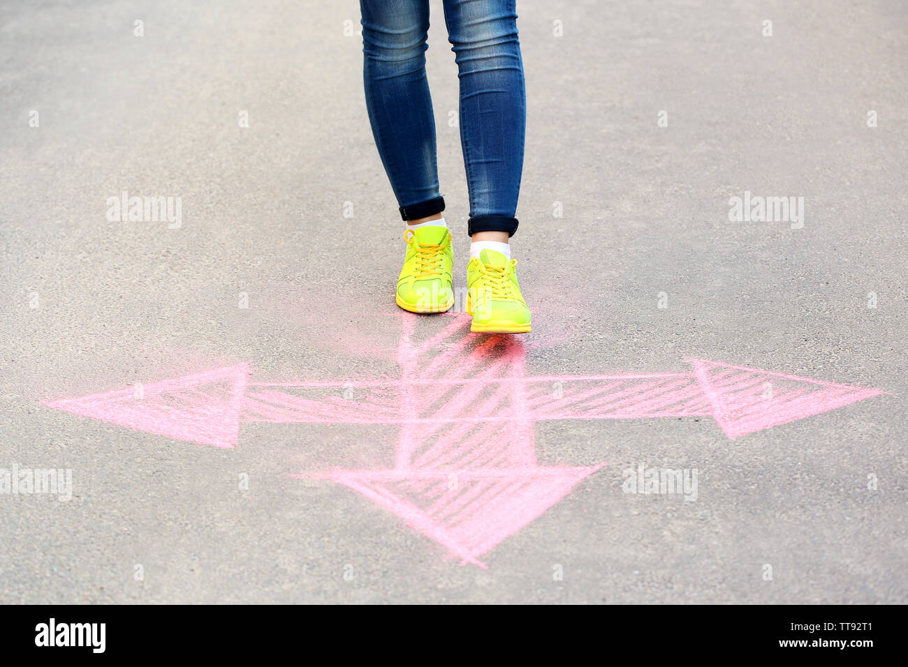Female feet and drawing arrows on pavement background Stock Photo - Alamy