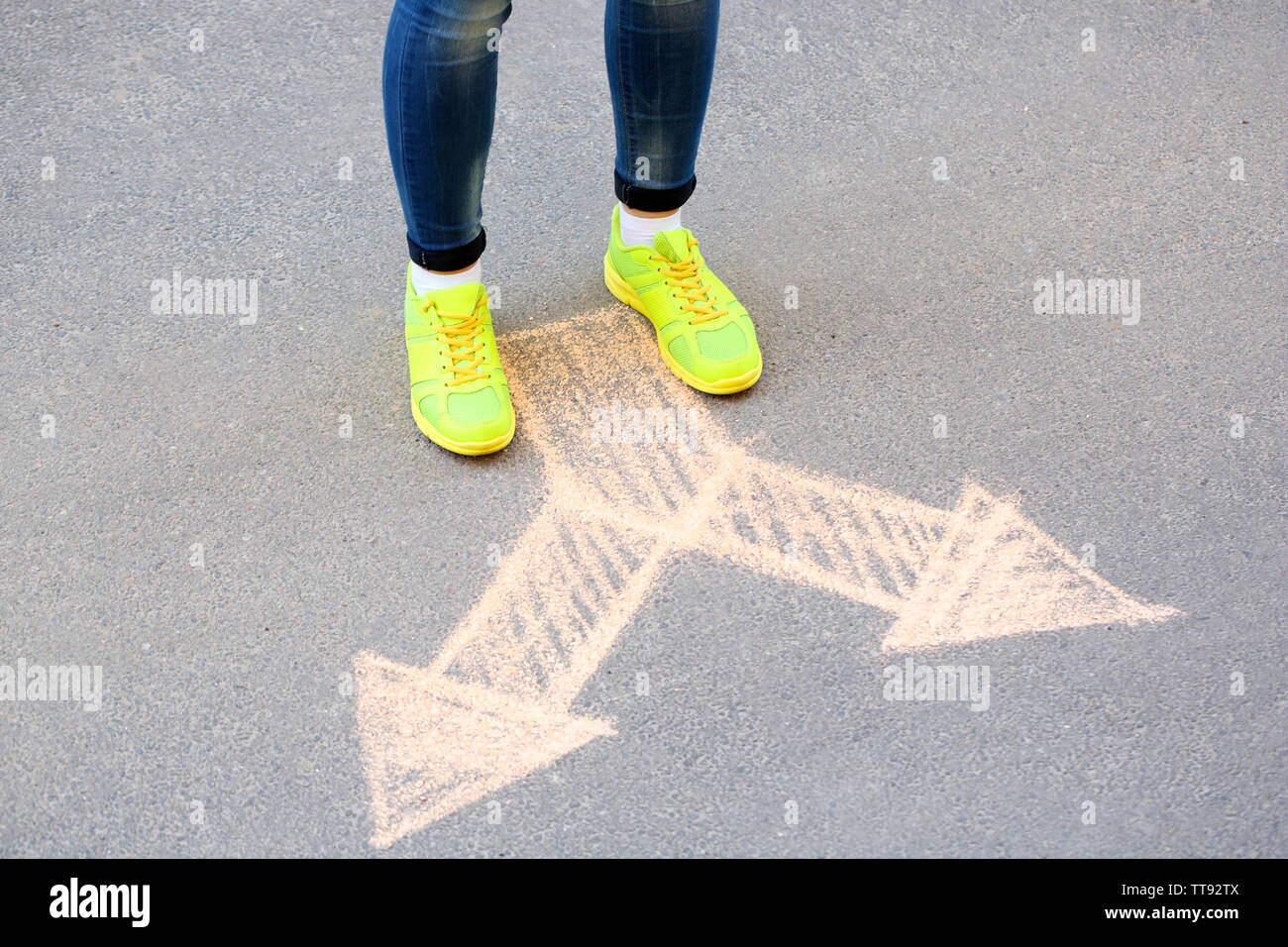 Female feet and drawing arrows on pavement background Stock Photo - Alamy