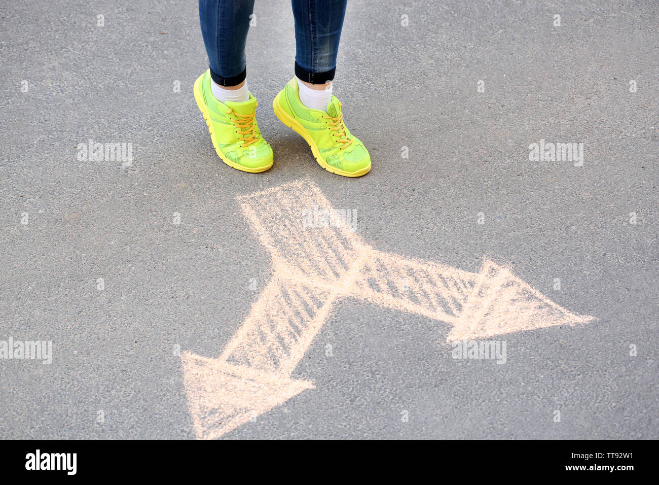 Female feet and drawing arrows on pavement background Stock Photo - Alamy