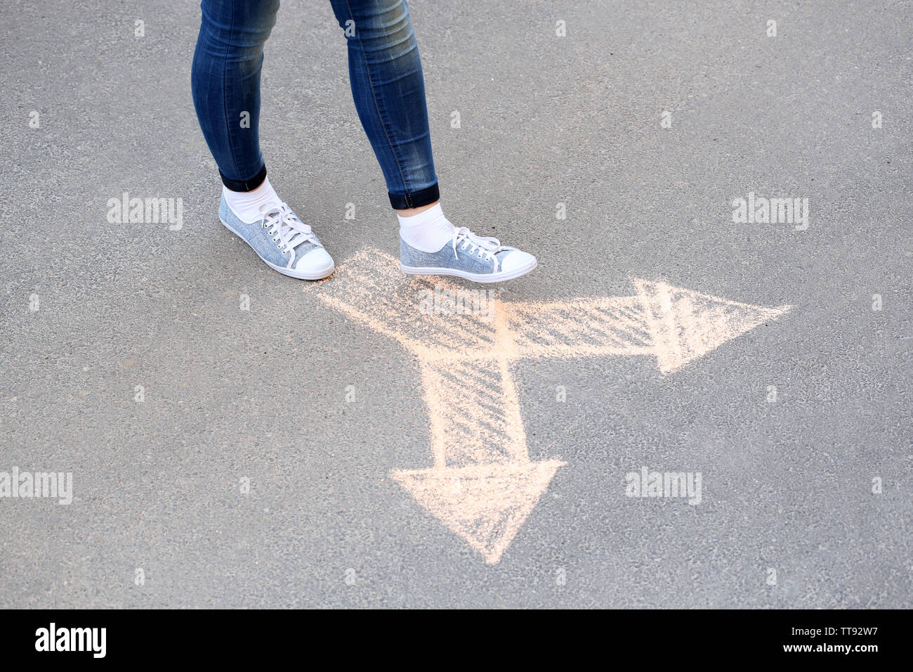 Female feet and drawing arrows on pavement background Stock Photo - Alamy