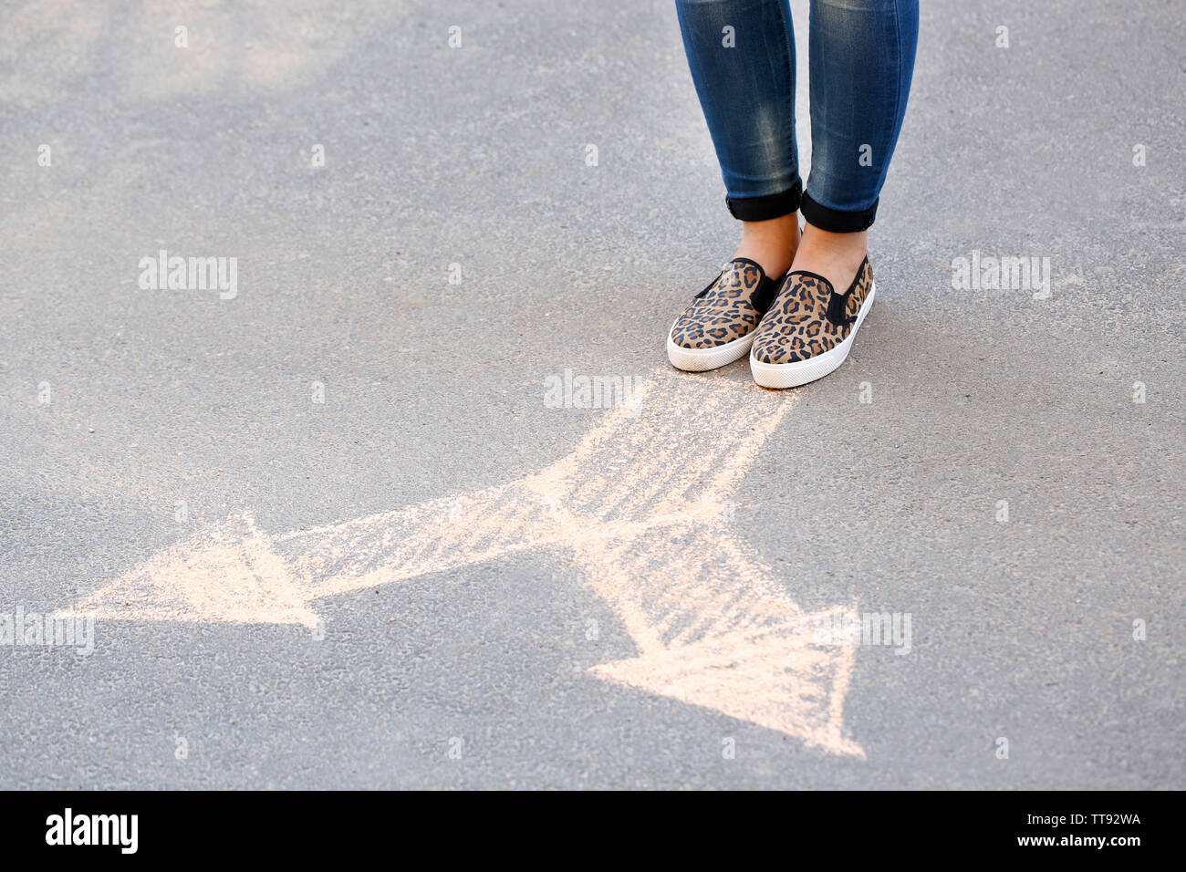 Female feet and drawing arrows on pavement background Stock Photo - Alamy