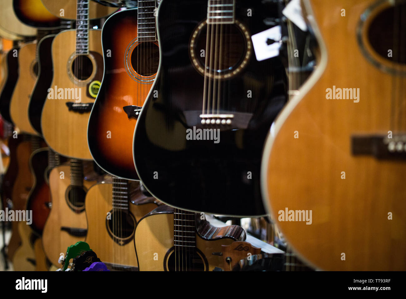metal string acoustic guitars hanging on the walls of music store ready ...