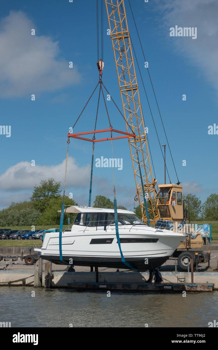 Power boat being lifted out of the water by a crane and cradle ...