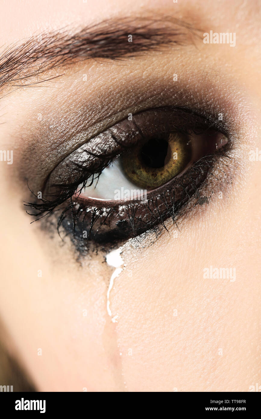 Eye of young woman with tear drop close up Stock Photo - Alamy