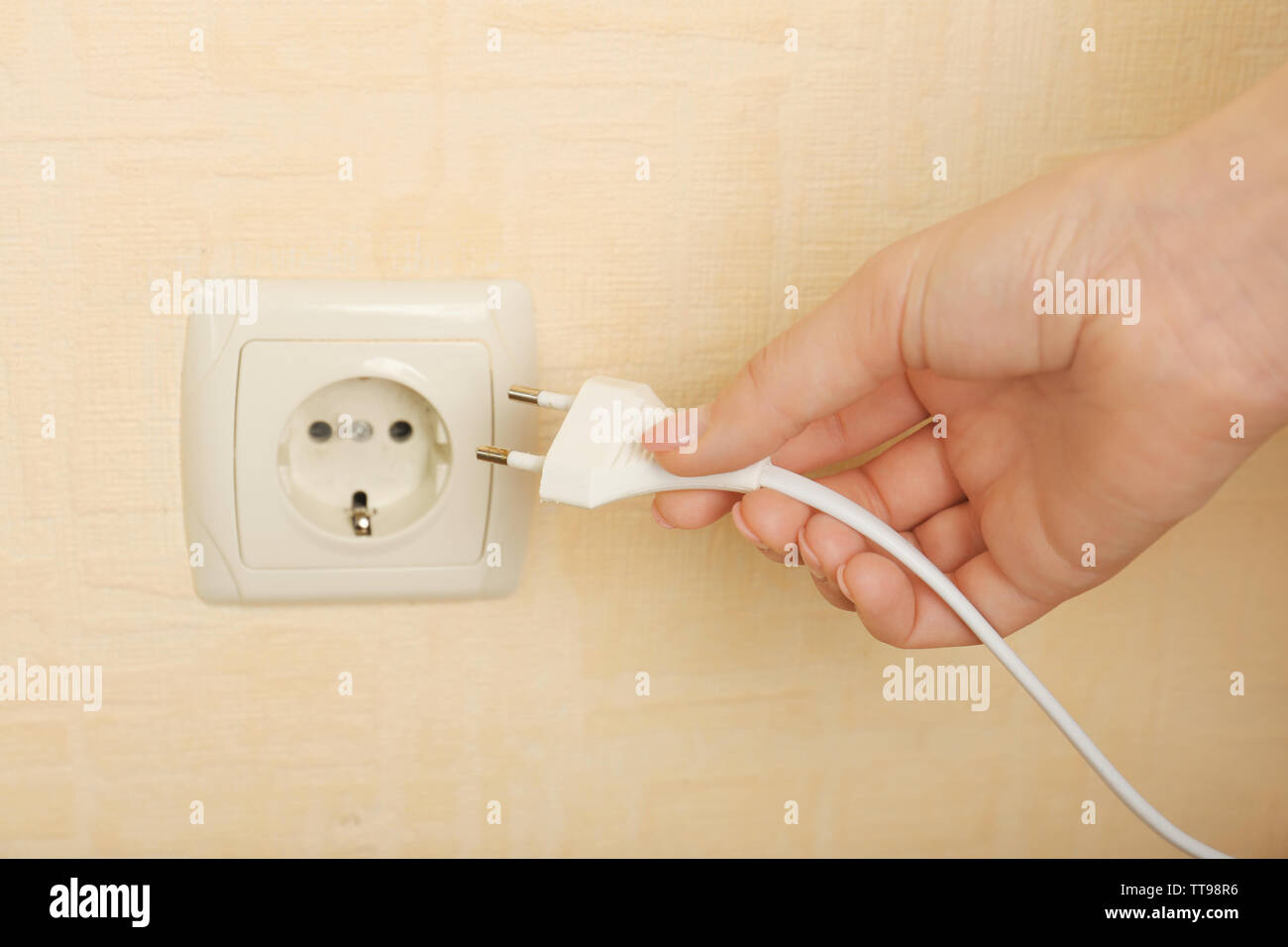 Hand putting plug in electricity socket close up Stock Photo - Alamy