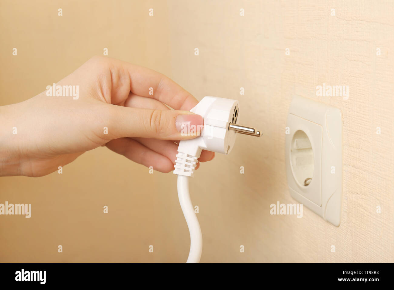 Hand putting plug in electricity socket close up Stock Photo - Alamy