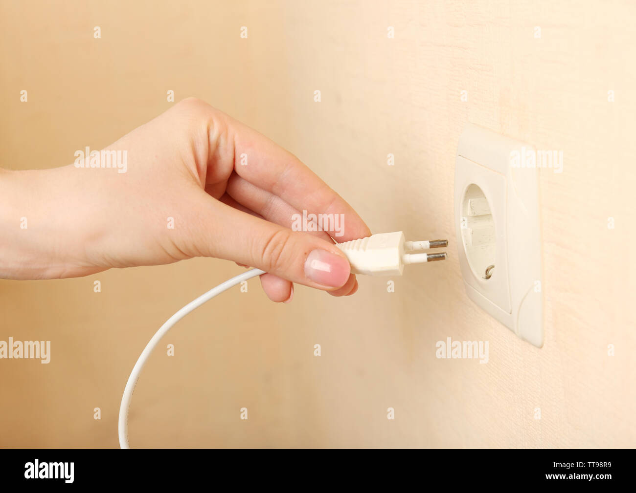 Hand putting plug in electricity socket close up Stock Photo - Alamy