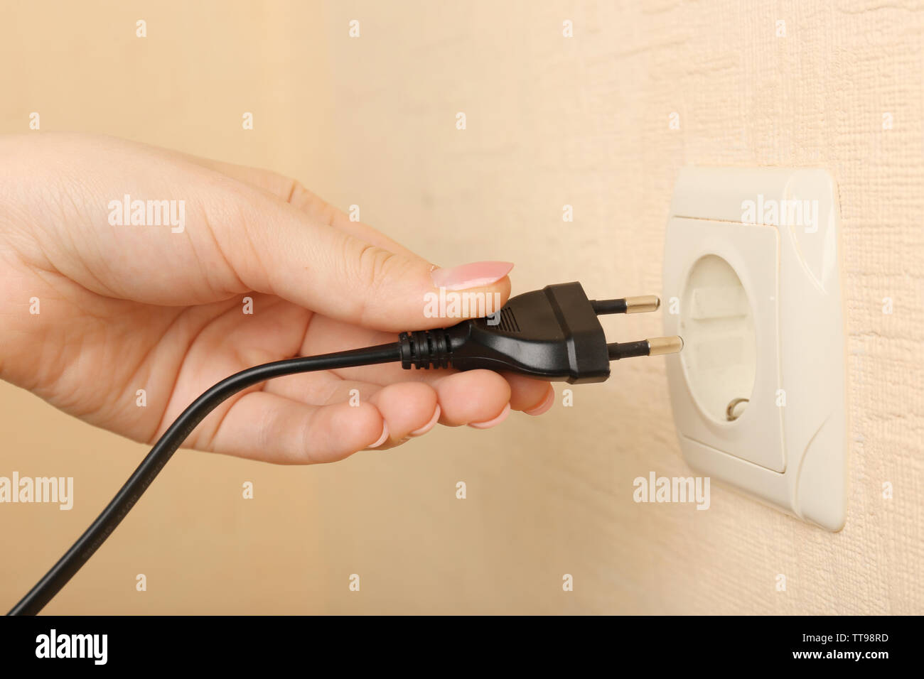 Hand putting plug in electricity socket close up Stock Photo - Alamy