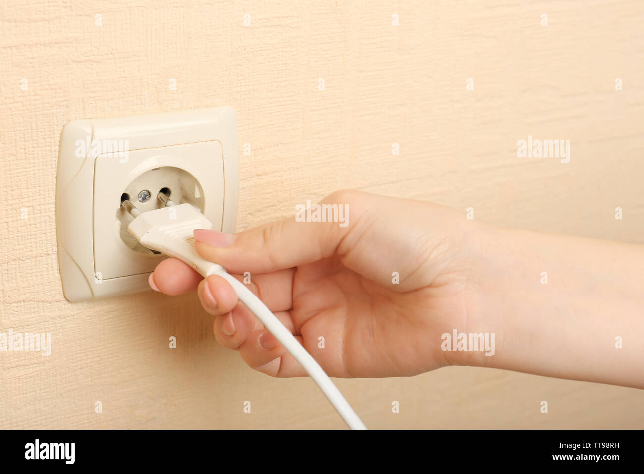 Hand putting plug in electricity socket close up Stock Photo - Alamy