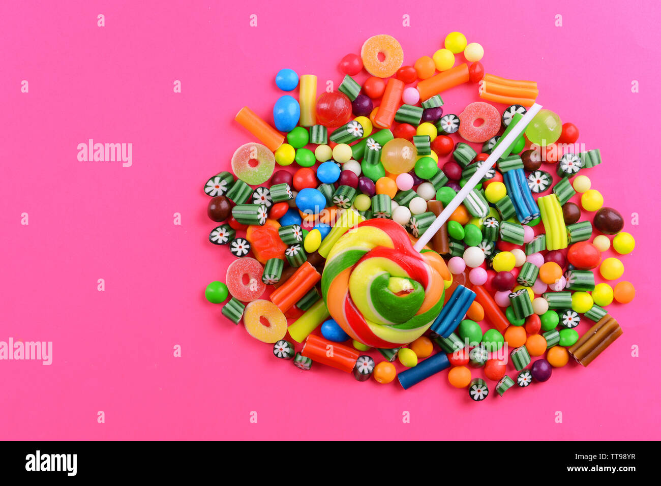 Colorful candies on pink background Stock Photo - Alamy