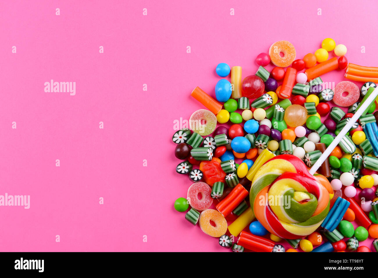 Colorful candies on pink background Stock Photo - Alamy