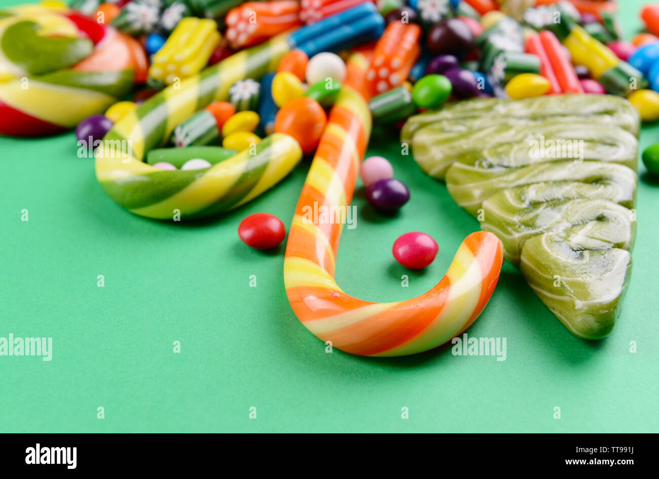 Colorful candies on green background Stock Photo - Alamy