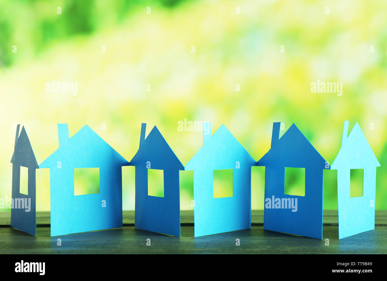 Paper houses on bright blurred background Stock Photo - Alamy