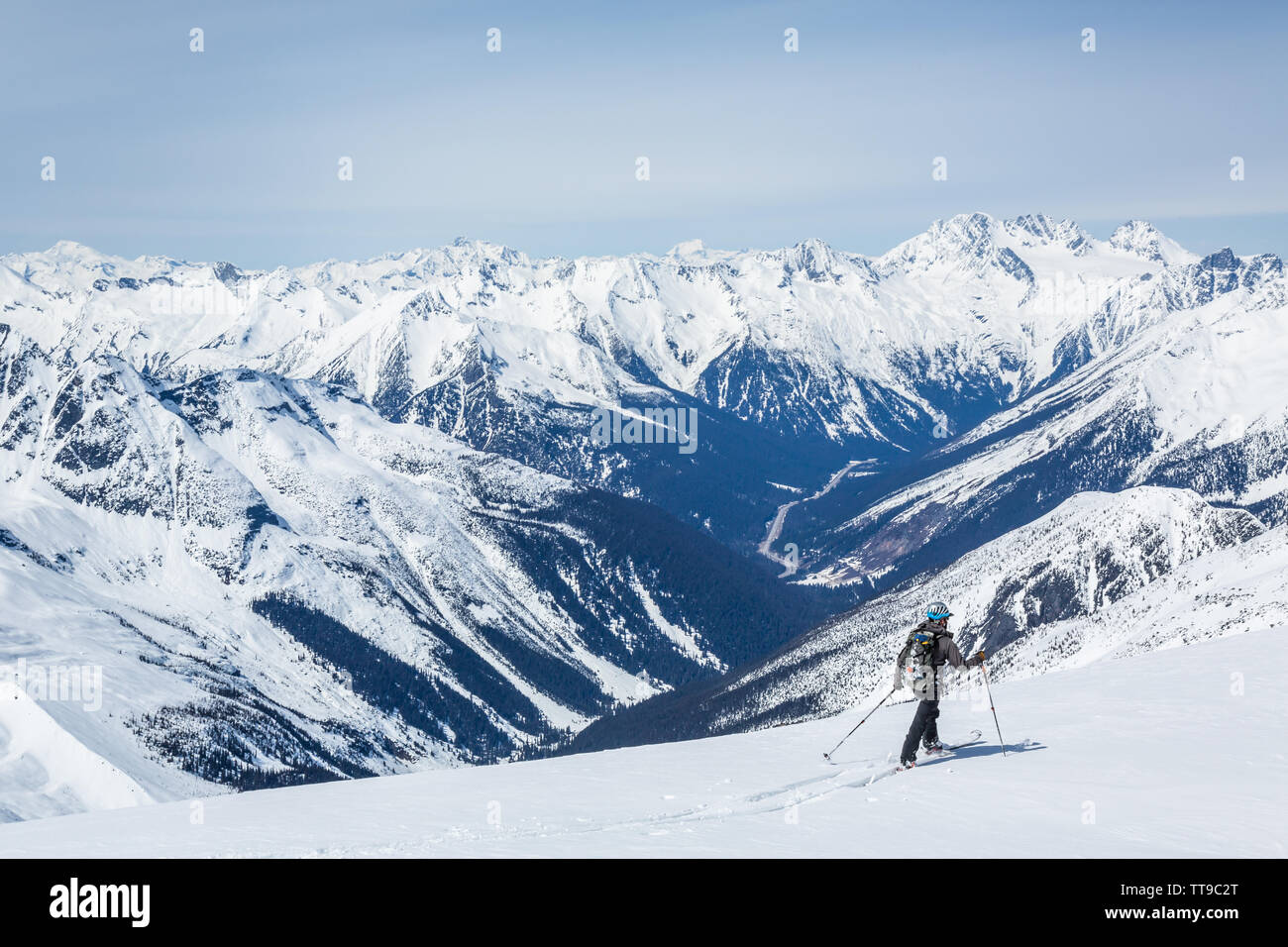 Skier hiking across to Youngs Peak overlooking the Asulkan Valley and ...