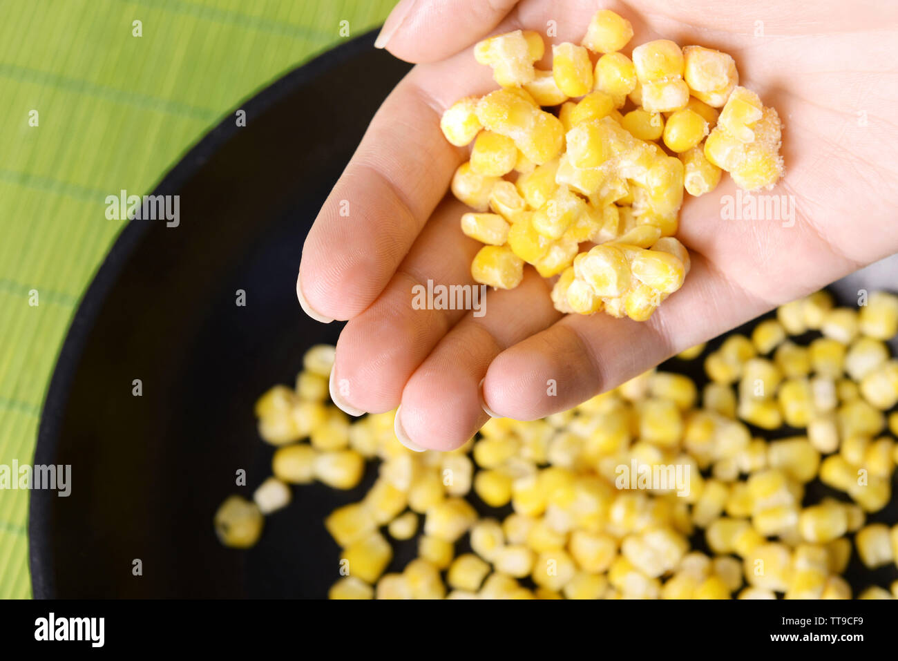 Hand holding frozen corn close up Stock Photo - Alamy