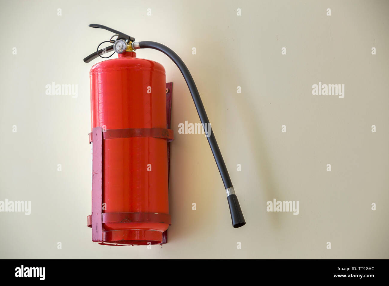 Fire extinguisher bright red isolated on white wall copy space ...