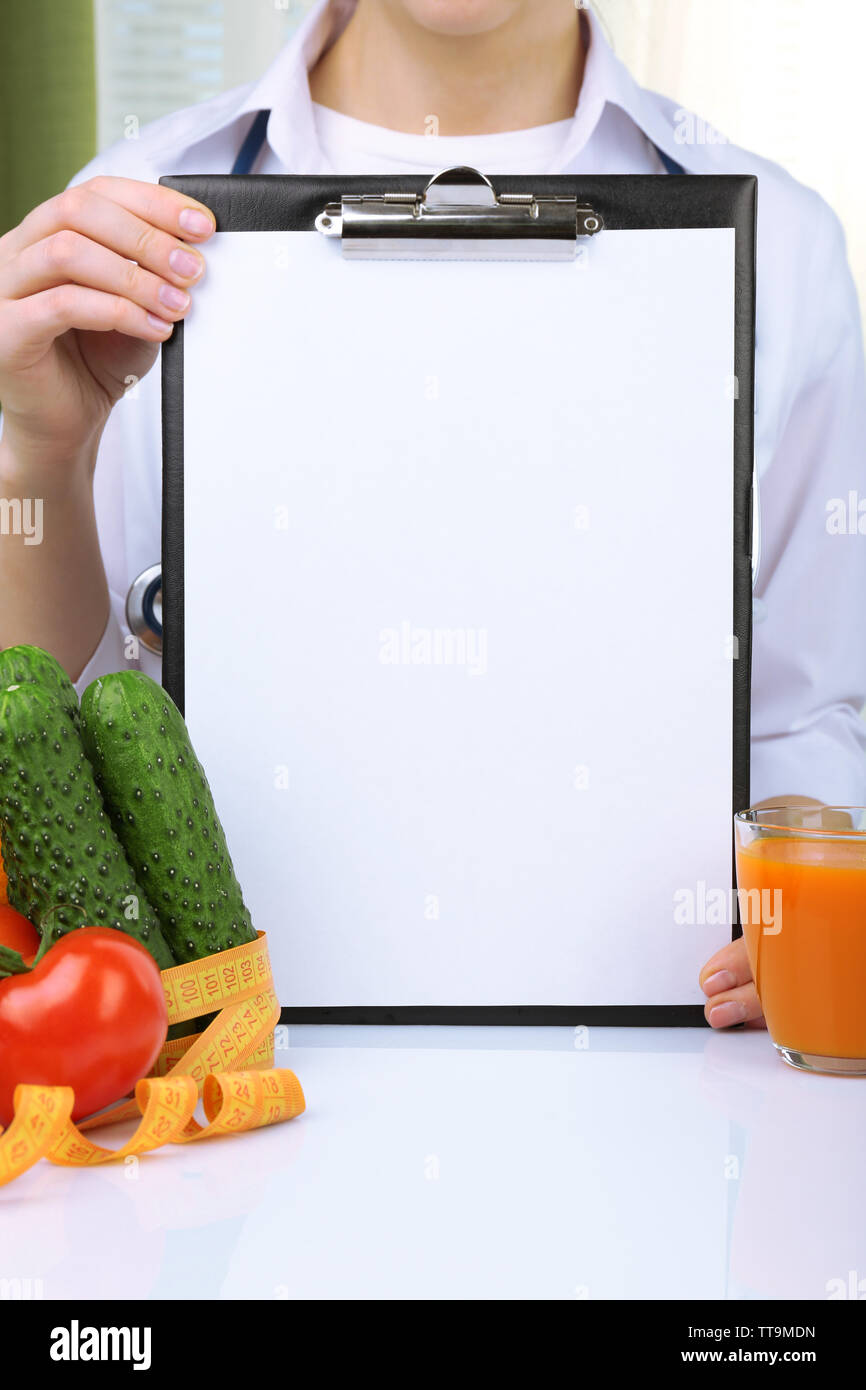 Nutritionist doctor with clipboard for diet plan in office Stock Photo ...