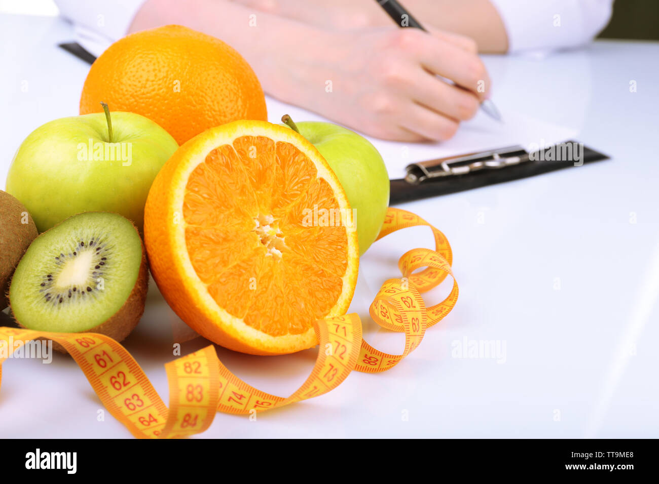 Nutritionist doctor writing diet plan in office Stock Photo - Alamy