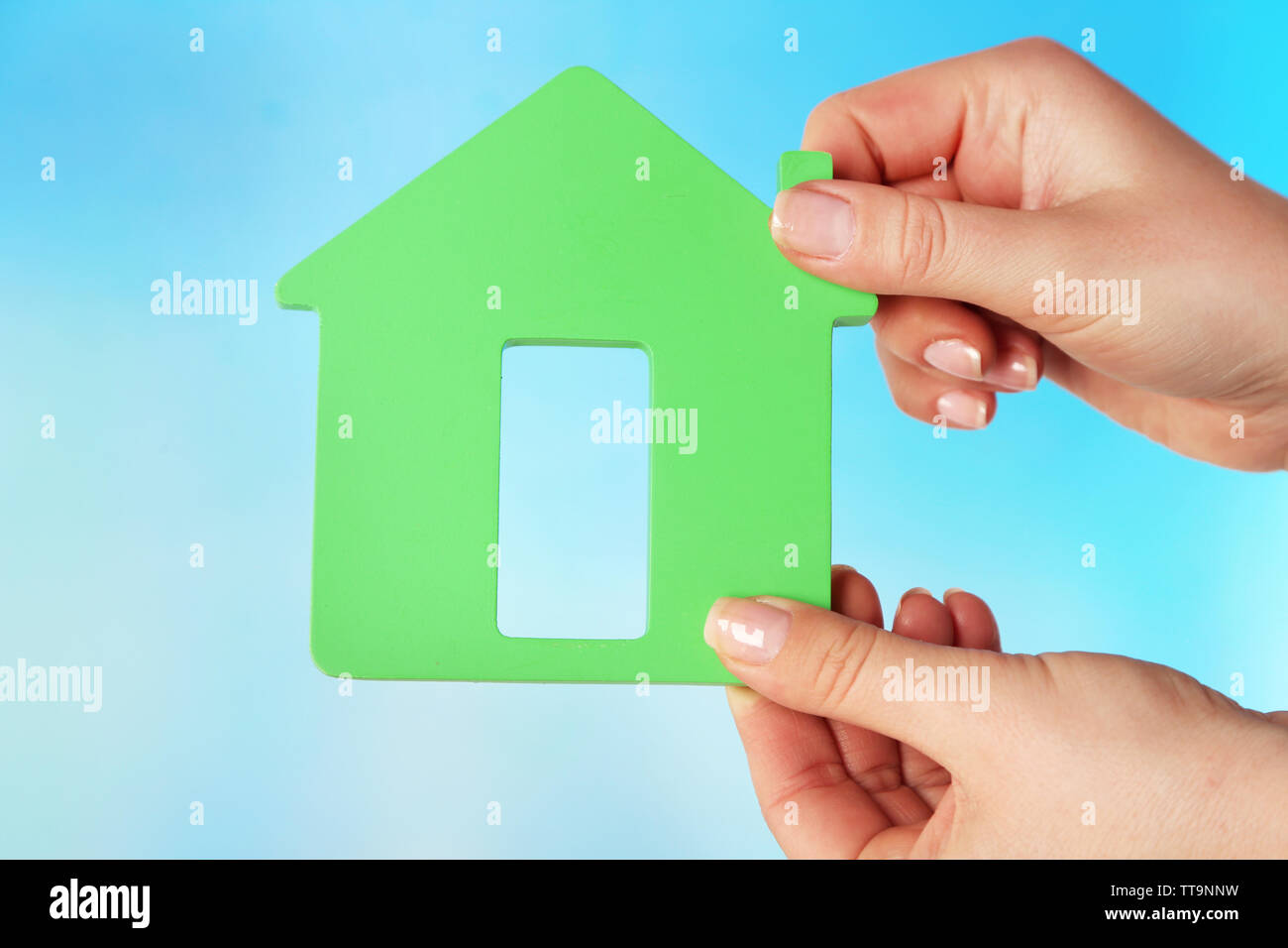 Female hands with model of house on color background Stock Photo - Alamy