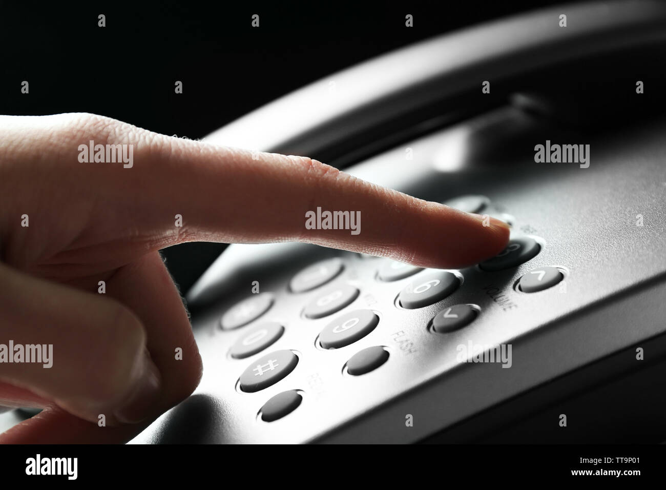 Finger pressing number button on telephone to make a call, close up ...