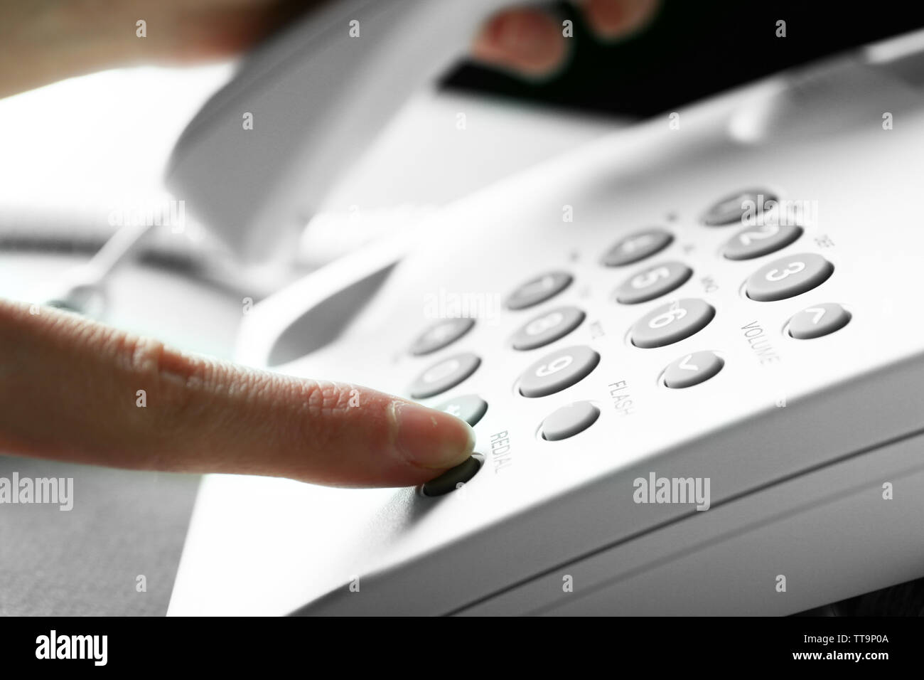 Finger pressing number button on telephone to make a call, close up ...
