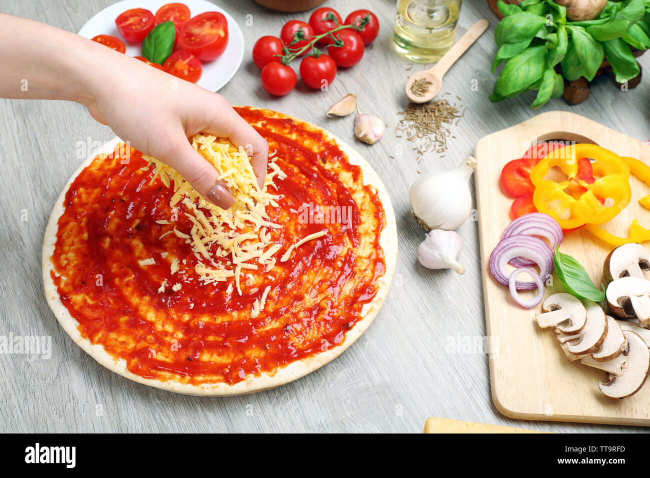 Woman making pizza on table close up Stock Photo - Alamy