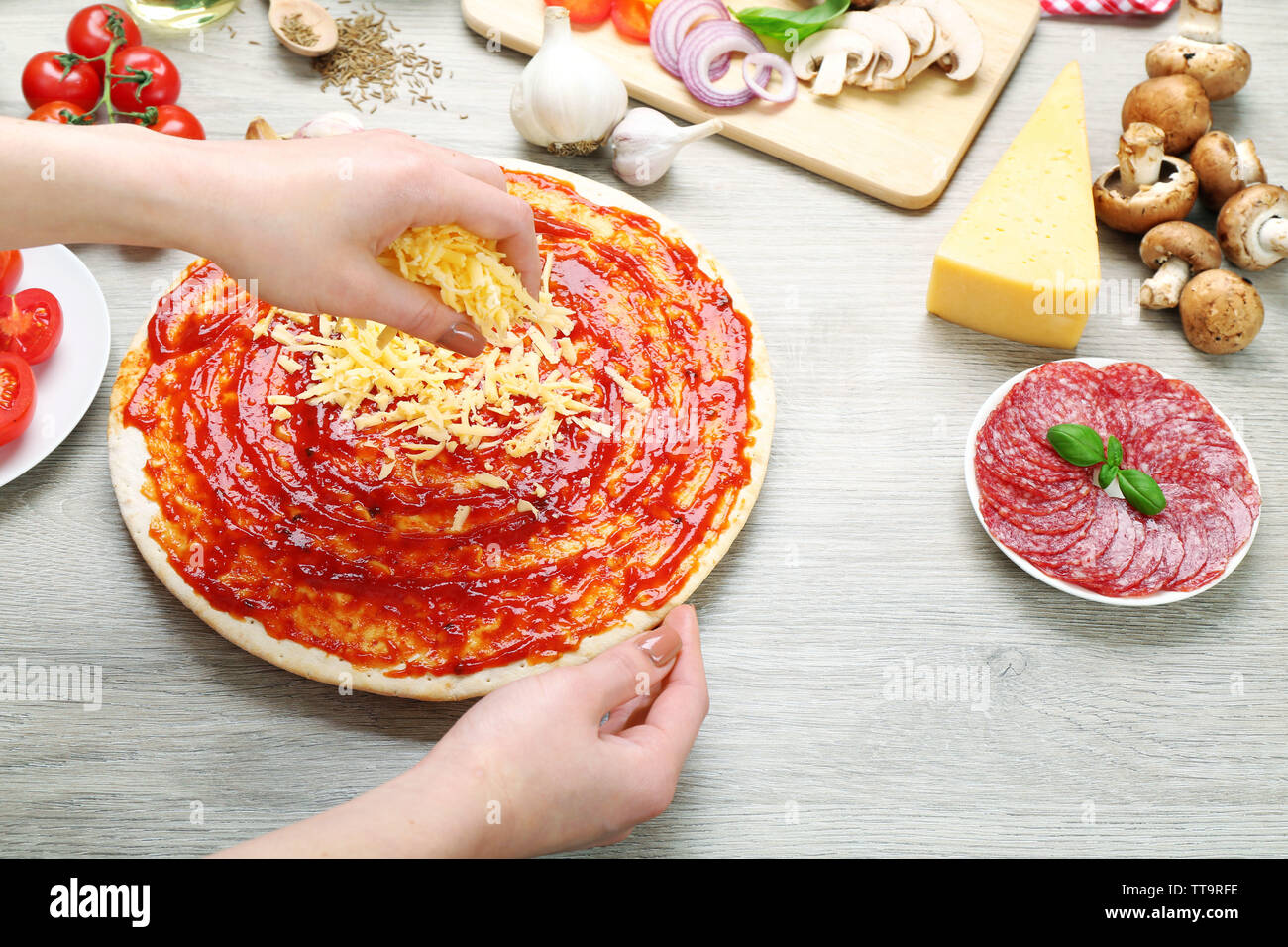 Woman making pizza on table close up Stock Photo - Alamy