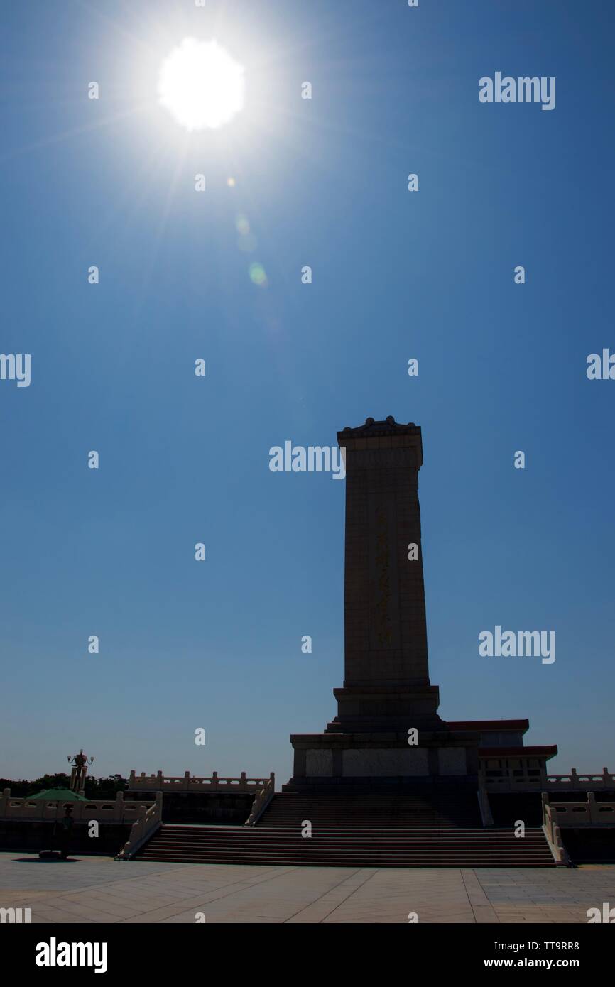 Bright sun in blue sky behind a silhouette of the Monument to the ...