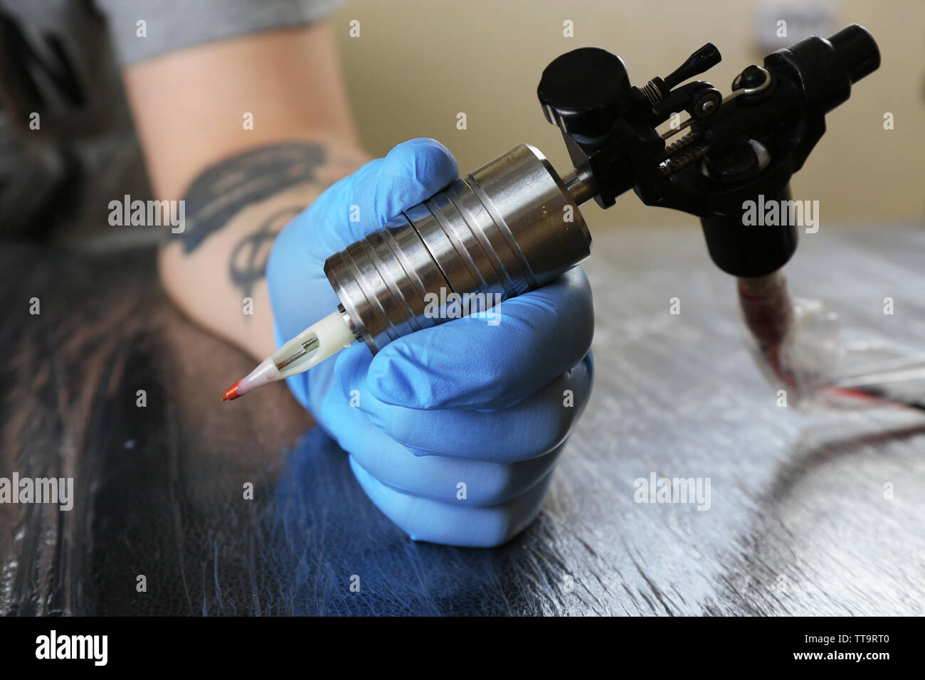 Tattoo artist at work close up Stock Photo - Alamy