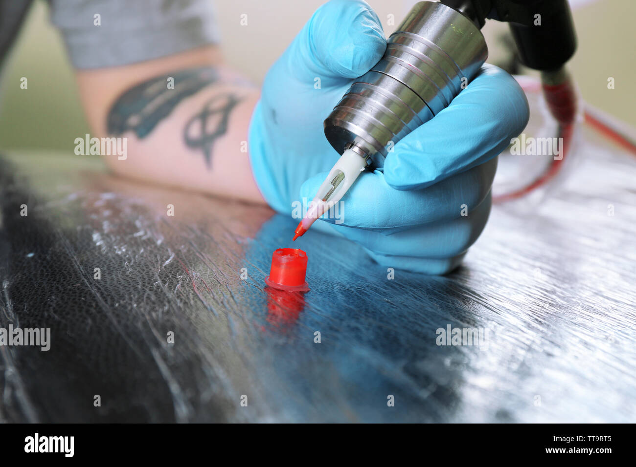Tattoo artist at work close up Stock Photo - Alamy