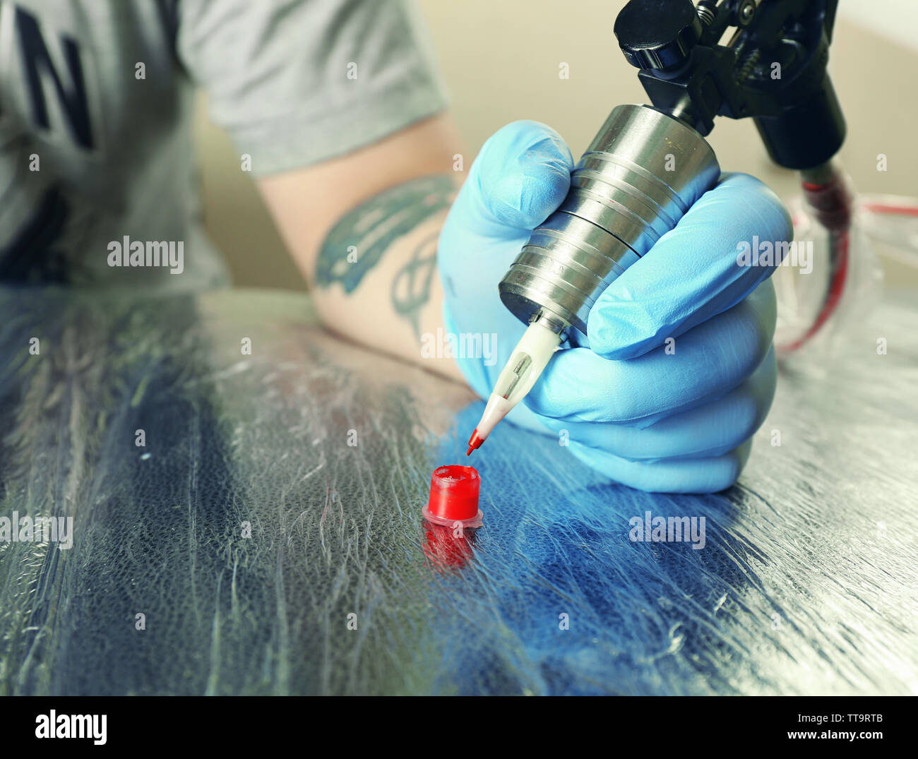 Tattoo artist at work close up Stock Photo - Alamy