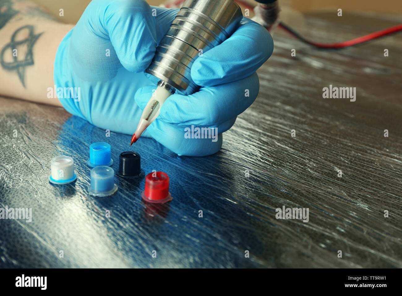 Tattoo artist at work close up Stock Photo - Alamy
