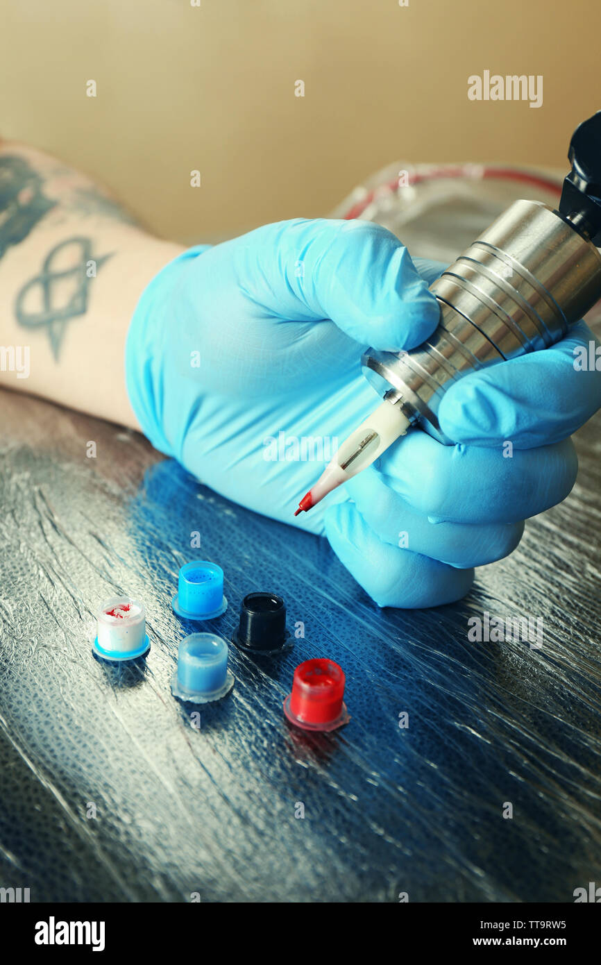 Tattoo artist at work close up Stock Photo - Alamy
